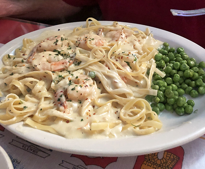 Fettuccine with shrimp that doesn't skimp on either cream or seafood – paired with those peas that somehow make you feel virtuous about the indulgence.