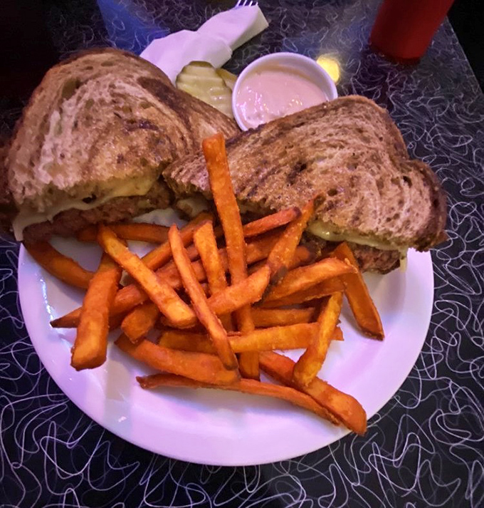 This isn't just a sandwich; it's a masterclass in comfort food architecture, with sweet potato fries playing a supporting role.