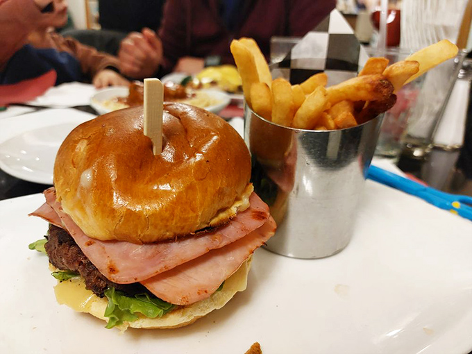 This isn't just a burger&mdash;it's an architectural achievement, where layers of ham, cheese, and beef create a skyscraper of flavor that demands both hands and several napkins.
