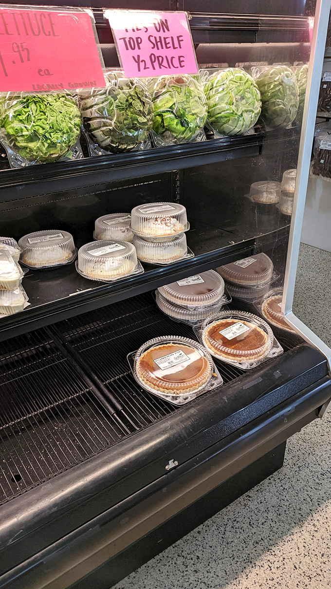 Fresh produce meets homemade pies in a display that should be illegal before noon. That lettuce is just there to make you feel virtuous before pie.