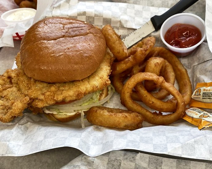 The pork tenderloin sandwich follows Indiana tradition: breaded, fried, and hanging gloriously off the bun like a crispy golden halo.