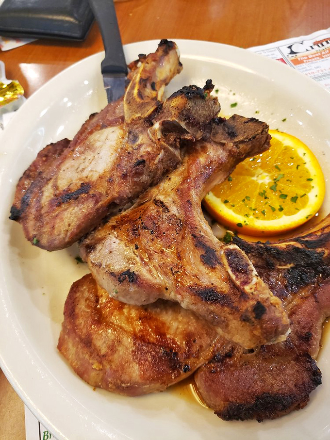 These pork chops aren't just cooked, they're performing a master class in the art of the perfect sear. That orange slice isn't just garnish&mdash;it's necessary brightness.