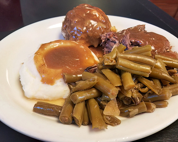 Pot roast that doesn't need a knife – just a willing fork and an empty stomach. Those green beans aren't a garnish; they're part of the conversation.