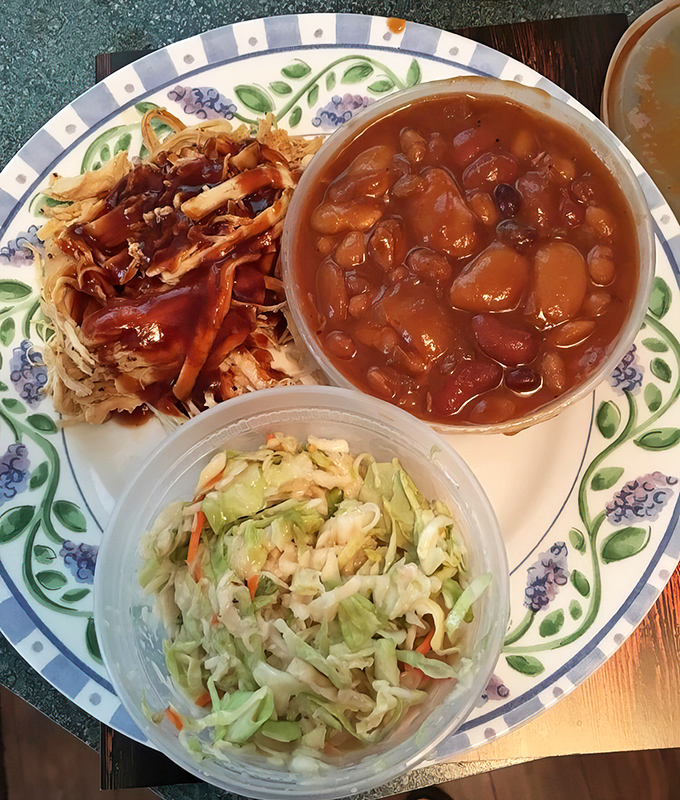 A perfect trifecta: pulled pork, baked beans, and coleslaw. The holy trinity of barbecue that makes you believe in culinary divinity.