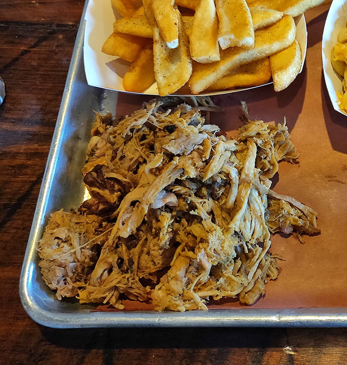 Pulled pork perfection alongside golden fries&mdash;a plate that whispers "I've been smoking since before dawn" in every tender, bark-speckled strand.