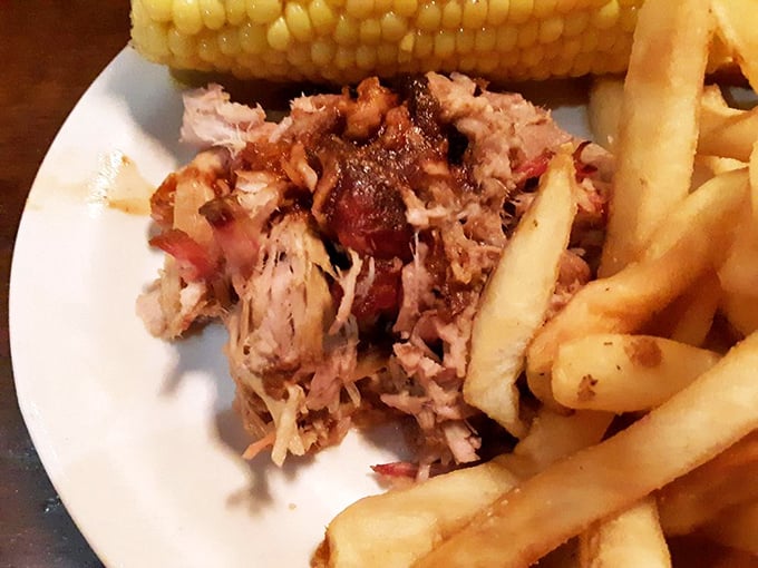 Pulled pork that's been coaxed to tenderness through hours of patient smoking, nestled beside golden fries and sweet corn. A Southern trinity.