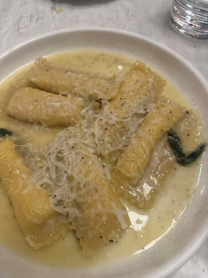 These pillowy pasta parcels swim in a buttery sea, topped with a snowfall of cheese. Comfort food that whispers, "Cancel your plans for the afternoon."