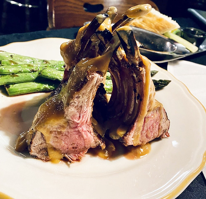 The rack of lamb stands at attention like meaty soldiers, their juicy pink centers revealing the kitchen's perfect timing.