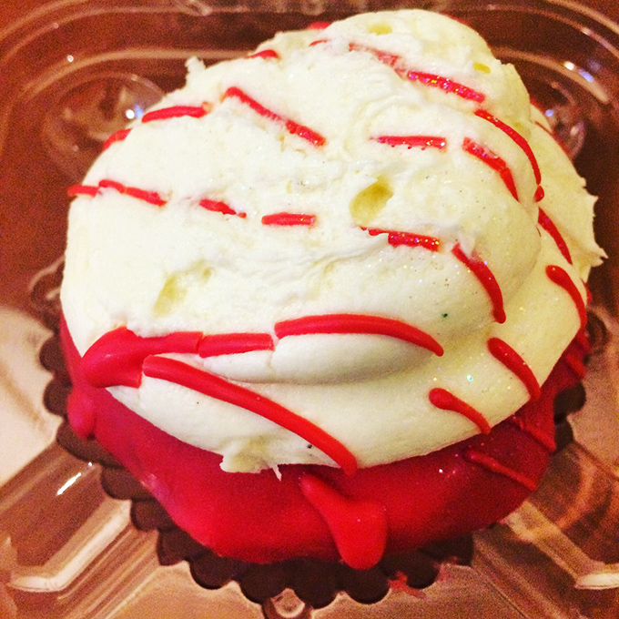 This red velvet cupcake wears its cream cheese frosting like a jaunty beret. The red drizzle adds just enough drama without overplaying its hand.
