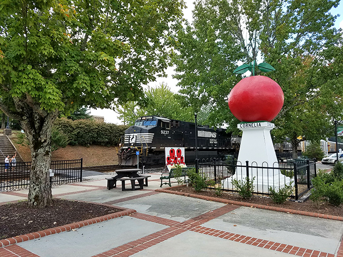 The perfect juxtaposition: a bright red apple monument with a Norfolk Southern train cruising by&mdash;two icons of Cornelia's heritage sharing the spotlight. 