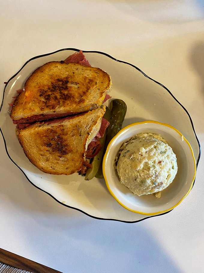 A proper Reuben isn't just a sandwich; it's architecture. Layers of pastrami, melted cheese, and tangy sauerkraut create a masterpiece that requires both hands and several napkins.