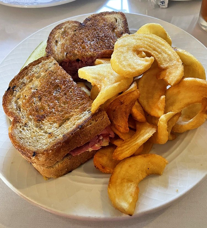 This isn't just a sandwich; it's a masterclass in the art of the perfect Reuben. Those house-made potato chips look like they shatter with each bite.