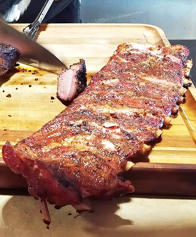 These ribs aren't just falling off the bone – they're practically filing for independence from it, with a bark that's worth every mile of the drive.