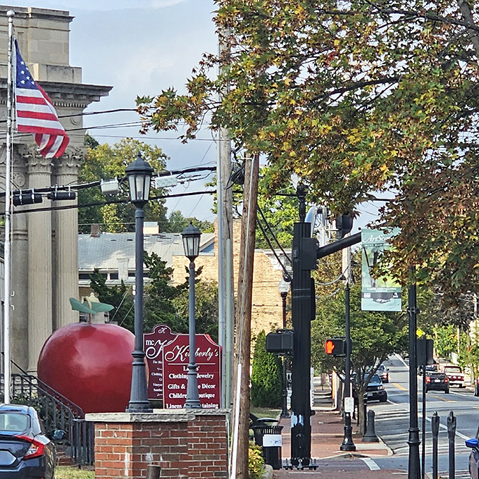 Peeking between lampposts and street signs, the giant apple adds a splash of unexpected color to Winchester's historic streetscape.