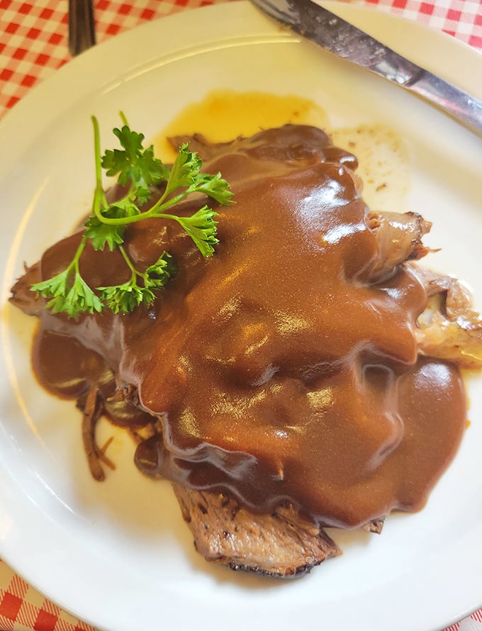 Roast beef swimming in gravy so rich it could pay off your student loans. The parsley garnish is just showing off at this point.