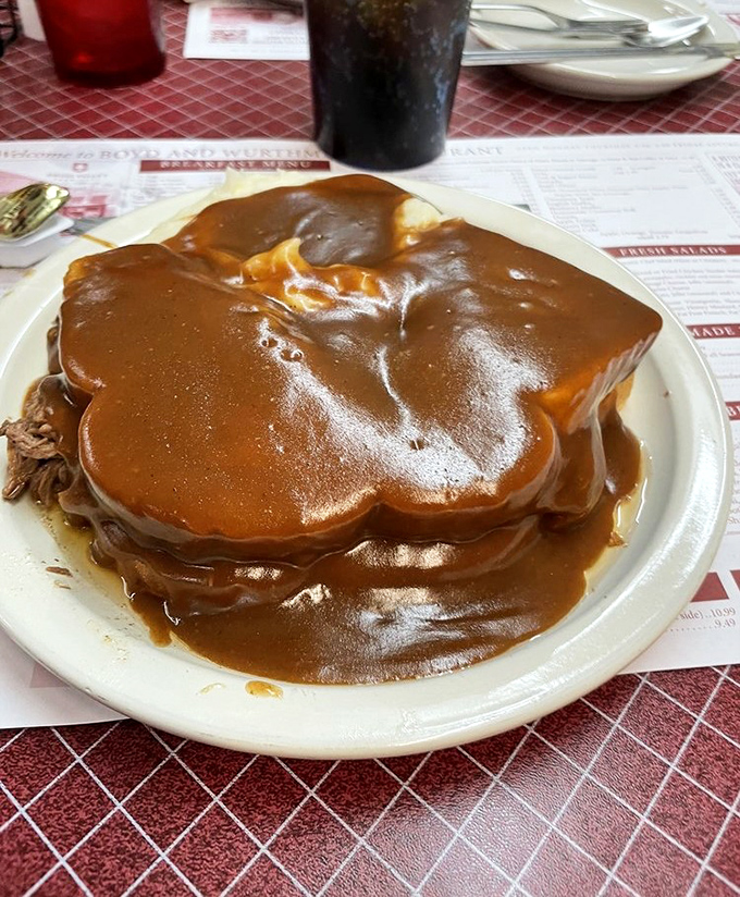 This isn't just roast beef—it's a gravity-defying monument to gravy engineering, where tender meat surrenders beneath a warm brown blanket of savory goodness.