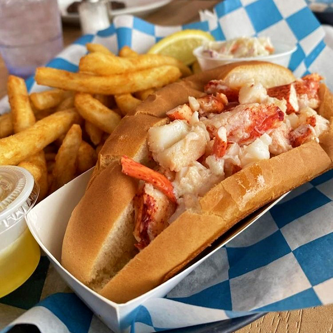 The Connecticut-style hot lobster roll—where butter is not just an ingredient but a philosophy. Those fries aren't jealous; they're honored to share the plate.