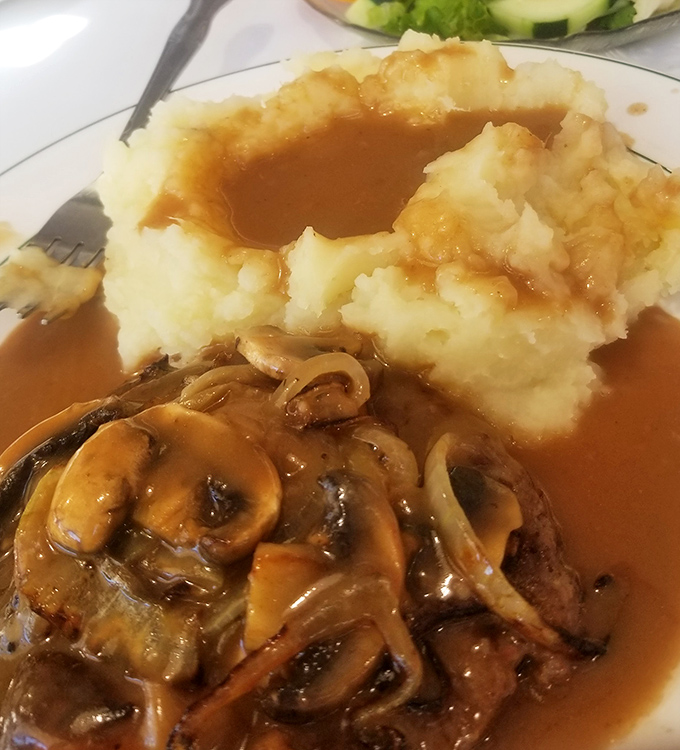 Mashed potatoes with a gravy lake and mushroom-topped salisbury steak &ndash; comfort food so nostalgic it should come with a hug from your grandmother.
