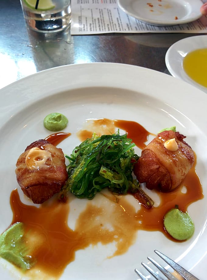 Bacon-wrapped scallops nestled beside seaweed salad&mdash;proof that sometimes the best things in life come in small, perfectly seared packages.