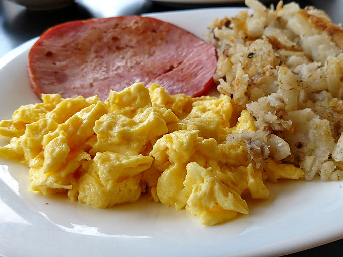Breakfast's holy trinity: fluffy scrambled eggs, savory ham, and those addictive home fries. Simple food done right is the highest form of culinary art.