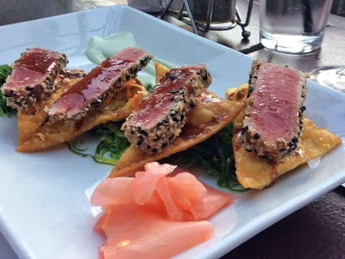 Seared tuna that's dressed better than most people at a wedding. Those perfect ruby centers are like culinary jewelry displayed on crispy wonton pedestals.