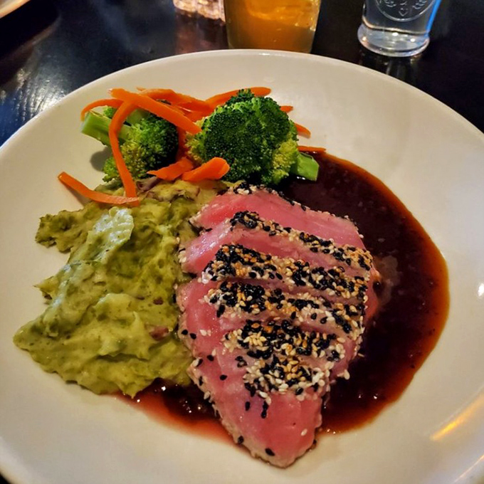 The sesame-crusted Ahi tuna arrives like an artist's palette&mdash;vibrant green wasabi mashed potatoes, crisp vegetables, and that glorious rare center demanding attention.