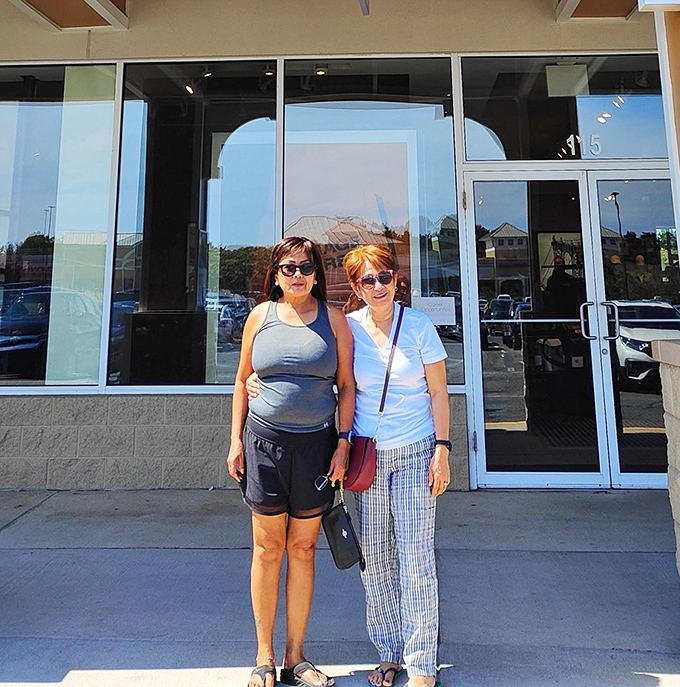 Two happy shoppers taking a well-deserved break after conquering the designer deals. Smiles say it all: mission accomplished!