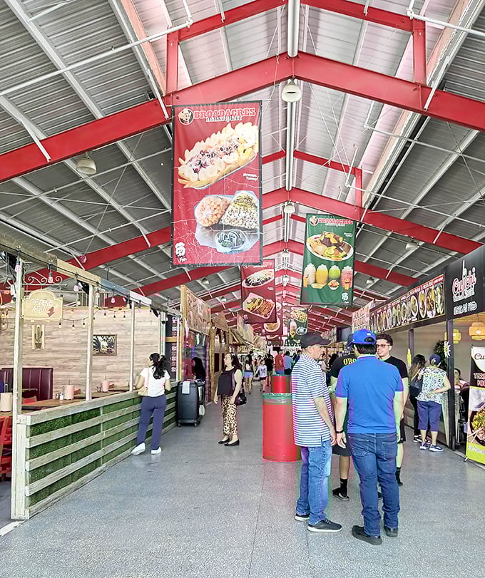 The covered food court buzzes with hungry shoppers contemplating their next culinary adventure, where the hardest decision is which delicious direction to take.