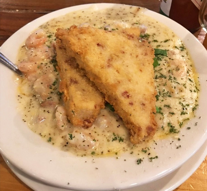 Crispy golden fish floating in a sea of creamy shrimp sauce &ndash; comfort food that hugs you from the inside out.