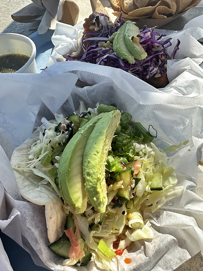 Fresh avocado slices stand at attention atop a bed of crisp vegetables—nature's perfect garnish for these picture-perfect tacos.