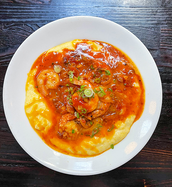 These aren't just shrimp and grits; they're plump Gulf beauties swimming in spicy tomato gravy atop a creamy cornmeal island.
