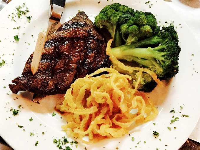 A masterclass in meat preparation &ndash; perfectly seared steak alongside crispy onion straws and vibrant broccoli creates a plate that's as beautiful as it is delicious.