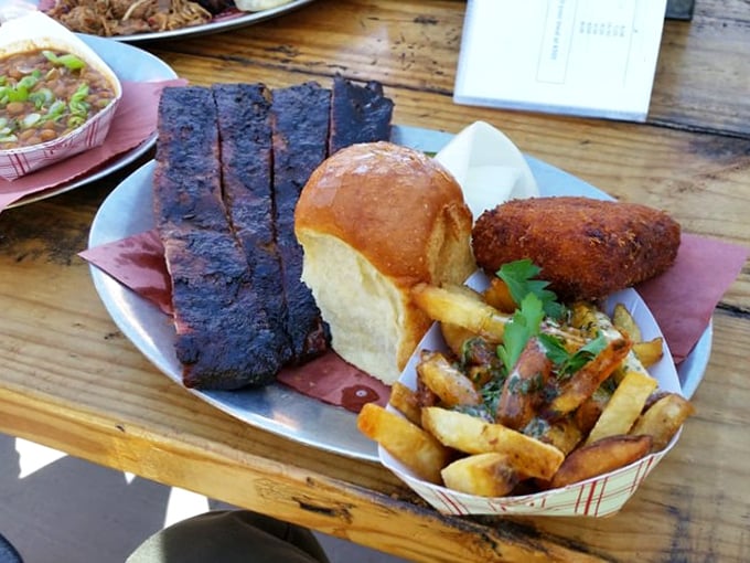BBQ perfection on display: ribs with the ideal bark, golden fries, and a roll that's ready to soak up every last drop of flavor.