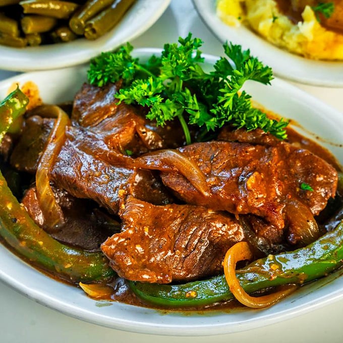 These smothered pork chops aren't just food &ndash; they're time travel. One bite and you're sitting in your grandmother's kitchen on a Sunday afternoon.