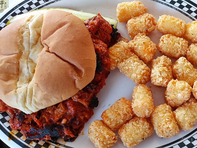 This isn't just a sandwich; it's a masterclass in comfort food architecture&mdash;spicy sauce, tender meat, and those tater tots looking like golden nuggets of happiness.