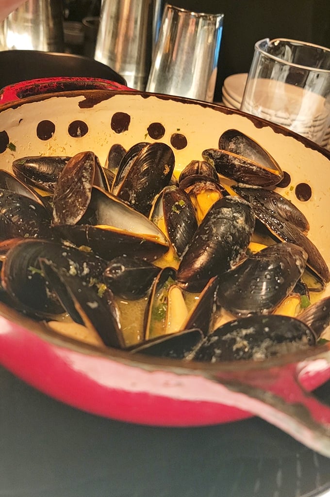 These mussels aren't just steamed, they're having a pool party in white wine and garlic. The empty shells will multiply faster than your dinner stories.