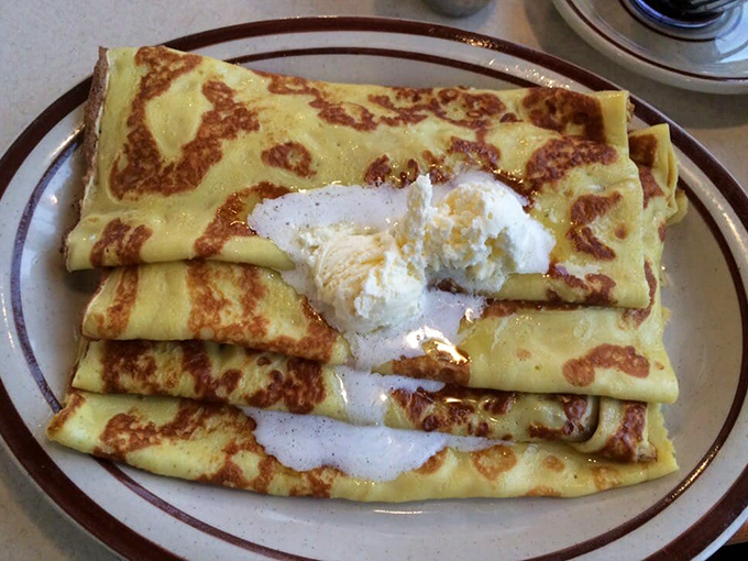 Swedish pancakes so thin and delicate they're practically crepes with Midwestern citizenship papers. That scoop of butter melting into them is performing sacred work.