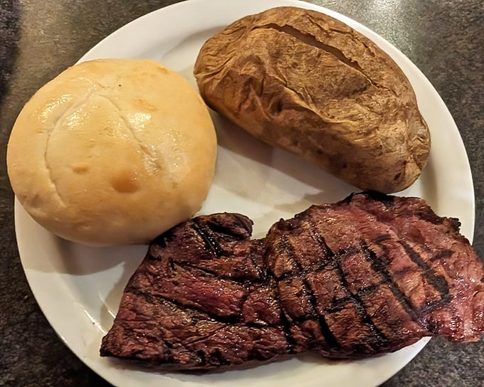 This perfectly grilled steak with a baked potato and roll isn't trying to impress food critics&mdash;it's too busy making your taste buds dance with joy.