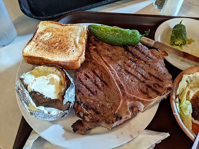 This T-bone stretches across the plate like a delicious geography lesson in perfect beef cuts.