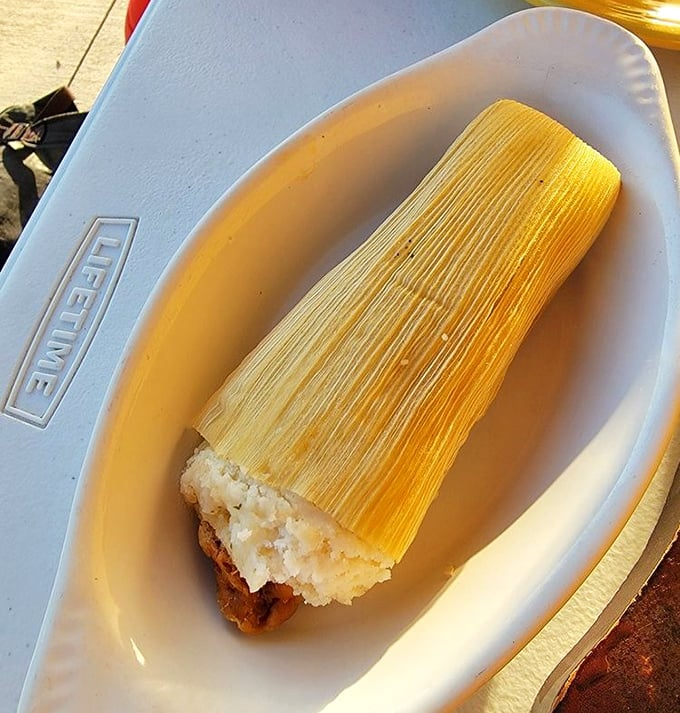 This tamale isn't just unwrapped, it's revealing itself like the main character in a corn husk telenovela.