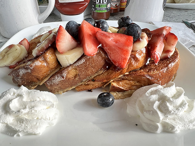 French toast that doesn't just wear fruit&mdash;it parades it proudly like edible jewelry, with whipped cream pillows waiting to catch any falling berries.