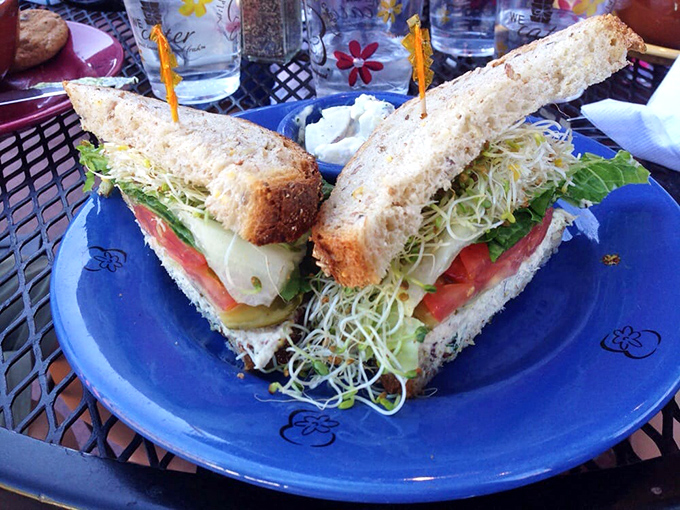 Layers of fresh veggies, cheese, and what looks like sprouts create a sandwich architecture Frank Lloyd Wright would approve of.