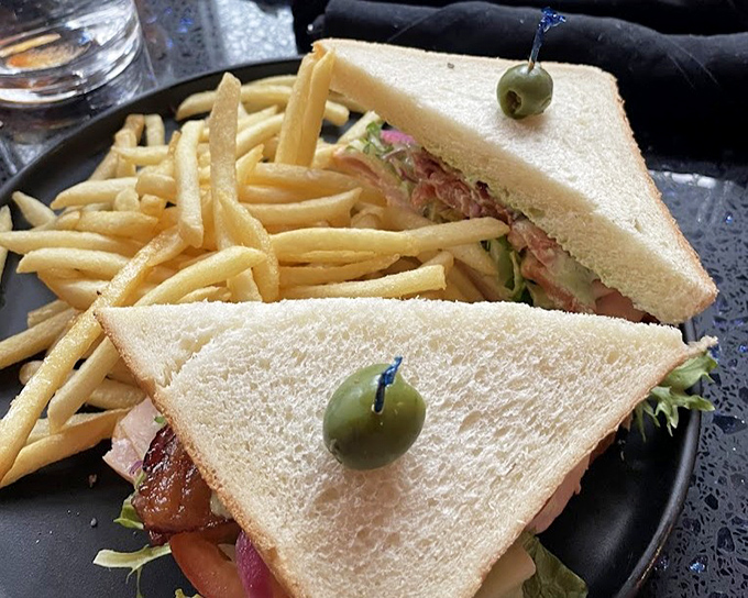 The humble sandwich, elevated to art form&mdash;perfectly toasted bread, fresh fillings, and those golden fries standing at attention like delicious soldiers.