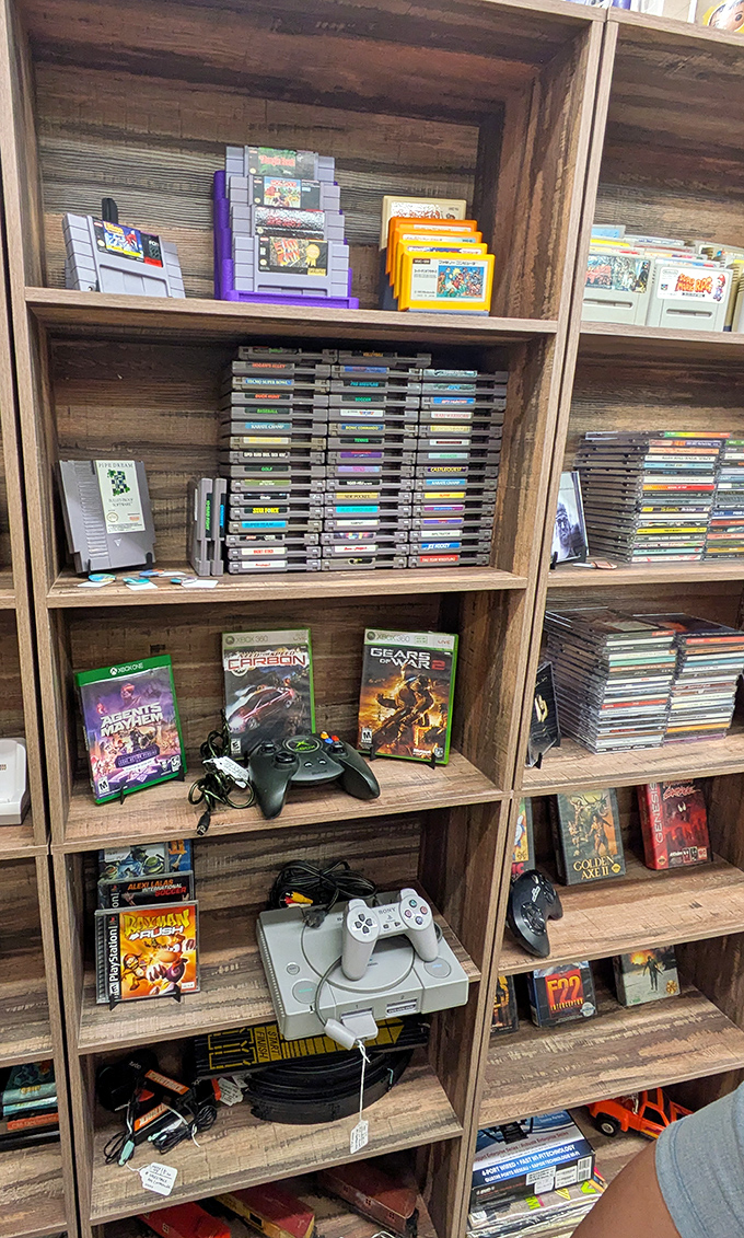 Video game heaven for the nostalgic soul. From NES cartridges to Xbox classics, it's every gamer's childhood arranged on wooden shelves.