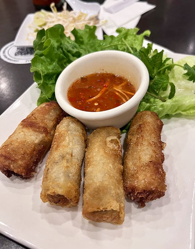 Golden Vietnamese egg rolls arrive with lettuce wraps and dipping sauce, crispy enough to hear across the table.
