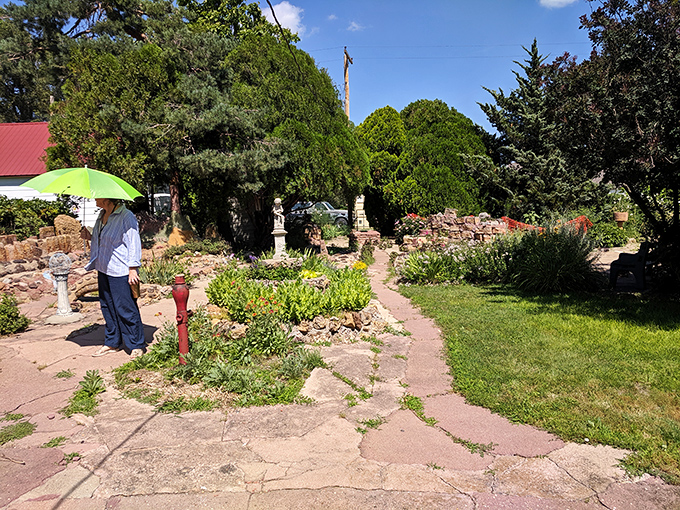 A visitor explores the Garden of Eden's stone sculptures, where S.P. Dinsmoor's concrete creations have been puzzling and delighting travelers since the early 1900s.
