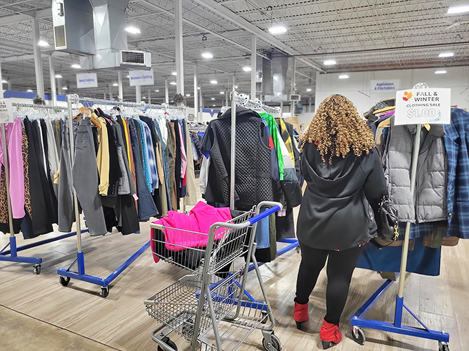 A shopper navigates the clothing forest with purpose&mdash;that focused expression is the universal look of someone who just spotted potential vintage gold.