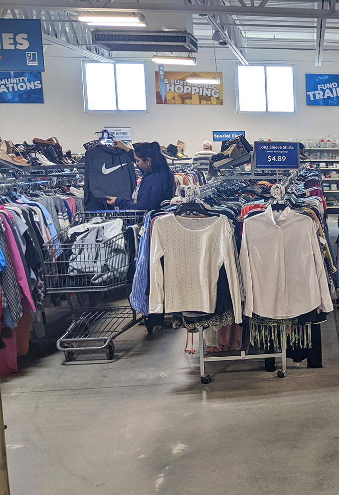 The thrill of the find! A shopper discovers a Nike gem among the racks, proving brand names and bargains can happily coexist.