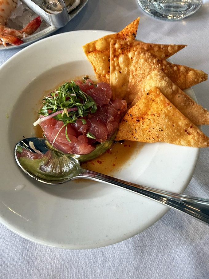 The yellowfin tuna poke arrives like jewels from the sea &ndash; ruby-red cubes nestled beside crispy wonton triangles, a perfect harmony of textures and flavors.