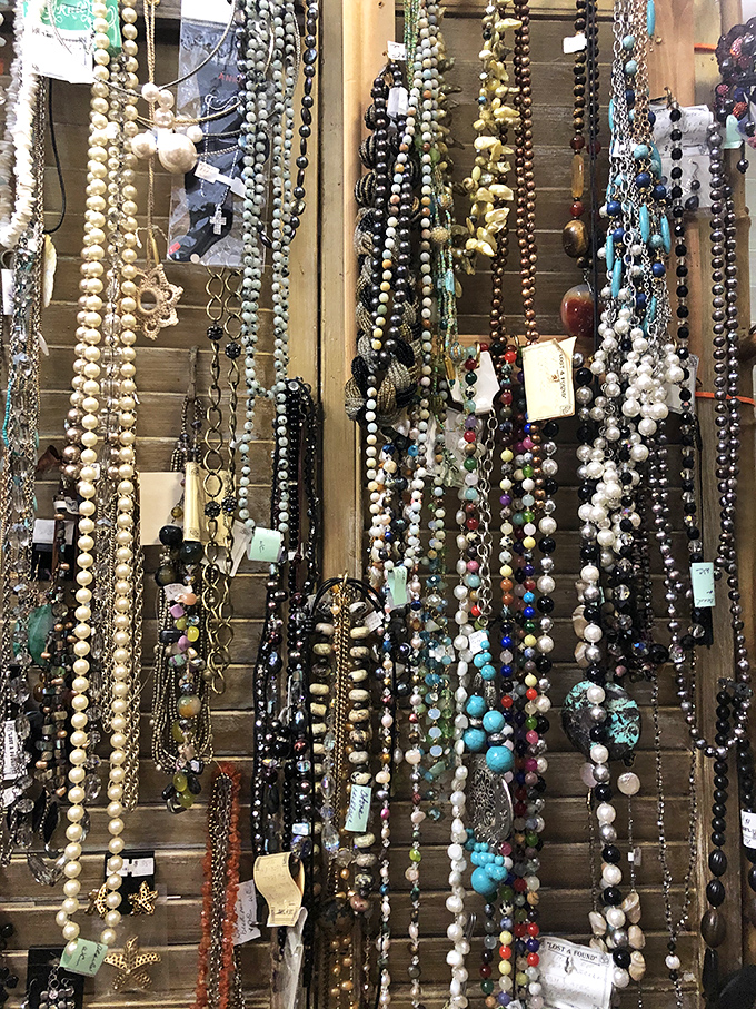 A jewelry lover's dream wall! Strands of pearls and colorful beads cascade like a waterfall of wearable history waiting for their next chapter.